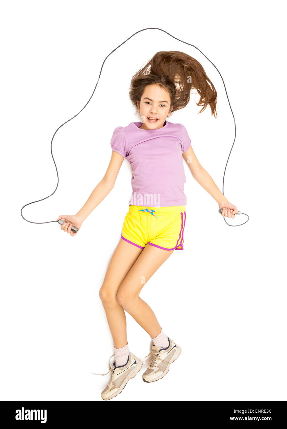 Isolated photo of cute smiling girl jumping with skipping rope Stock ...