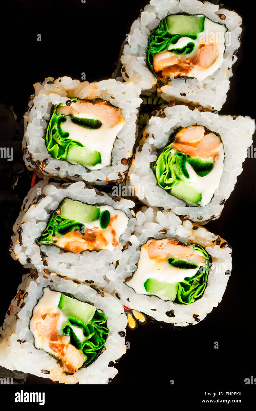 six Japanese rolls on a black dish Stock Photo - Alamy