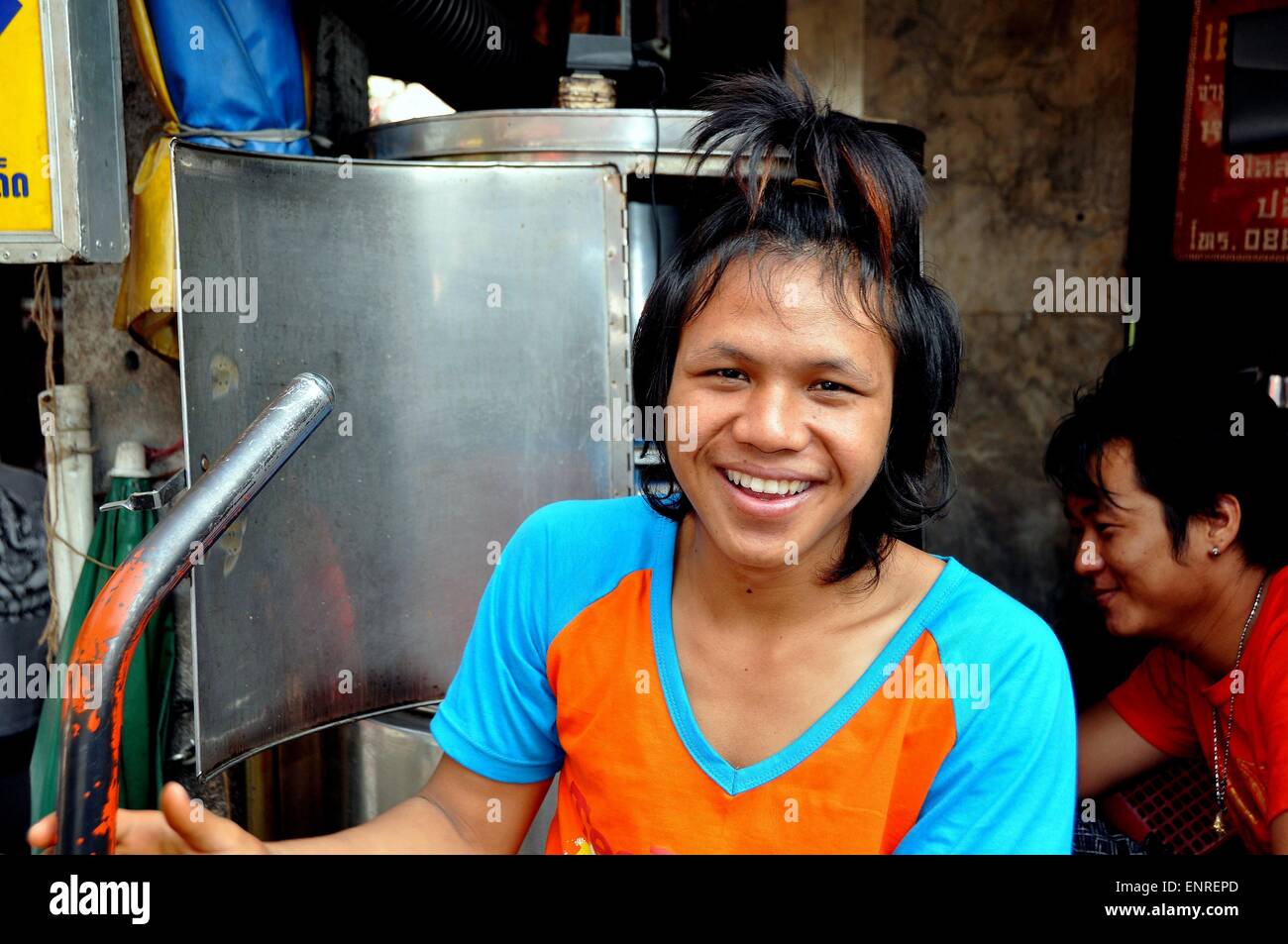 Bangkok, Thailand: Thai youth flashes his winning smile pushing a hand ...