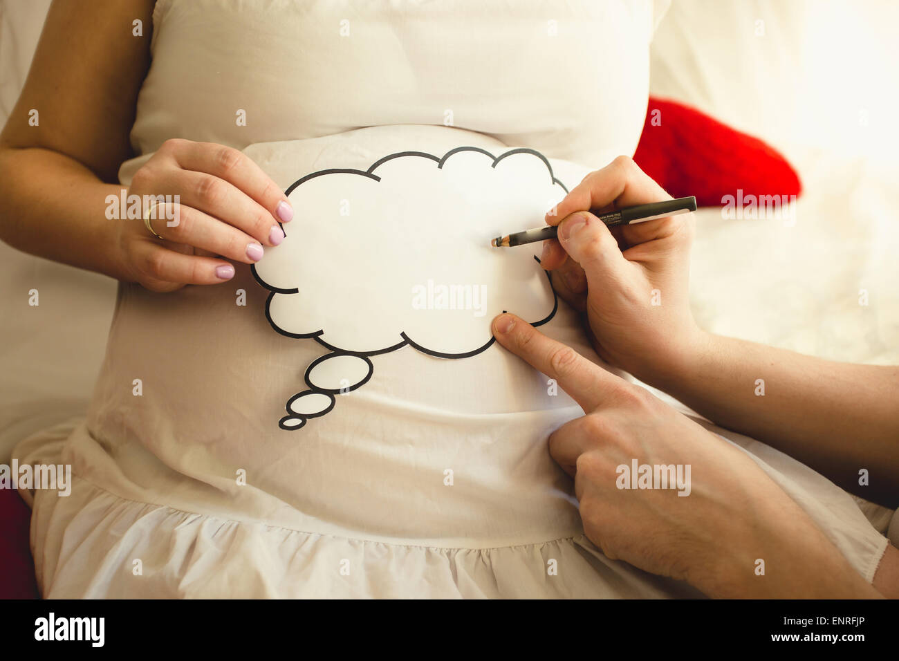 Closeup of photo of man writing on paper sign on wife's pregnant ...