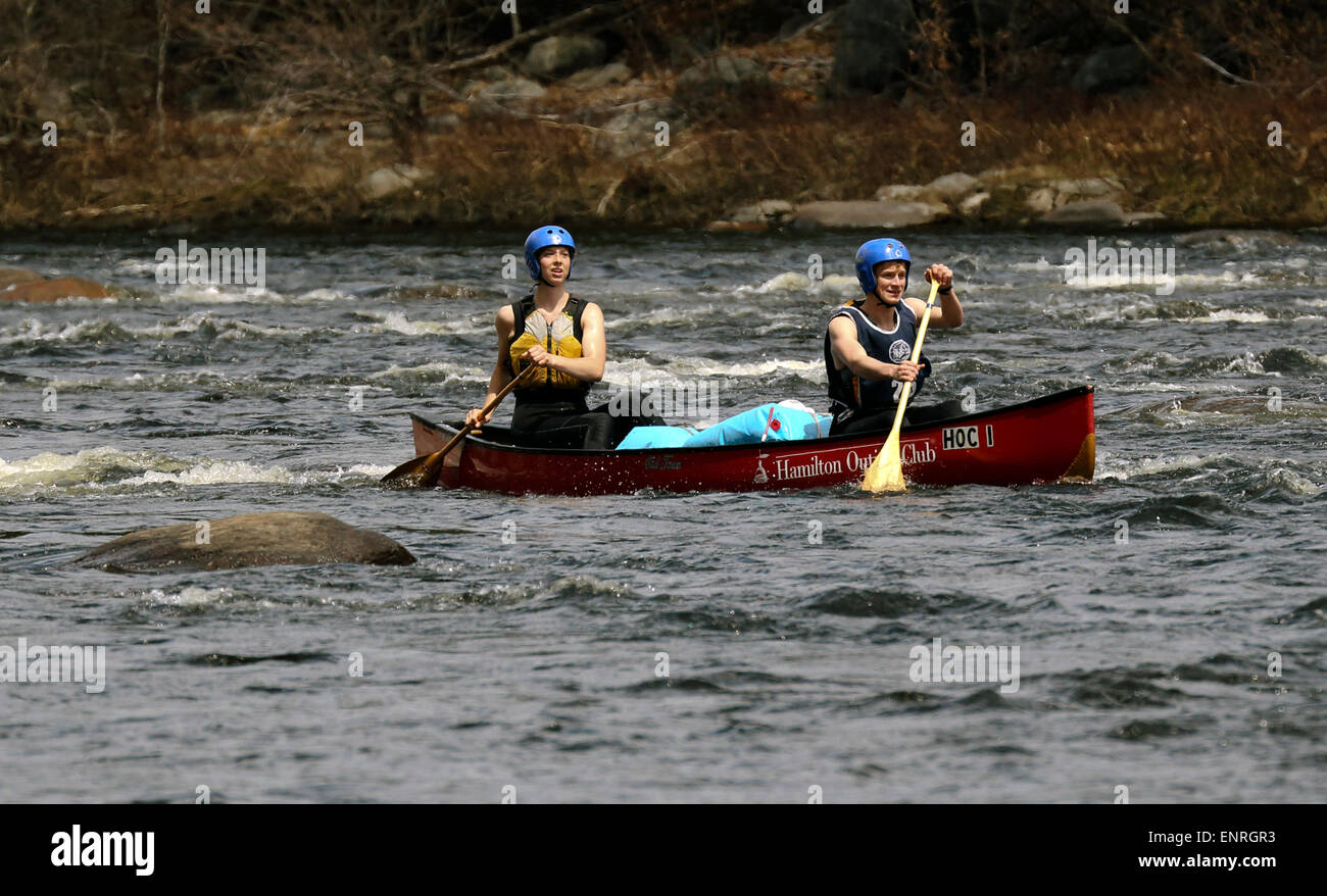 Two in a canoe a man and woman shooting running the rapids on the ...