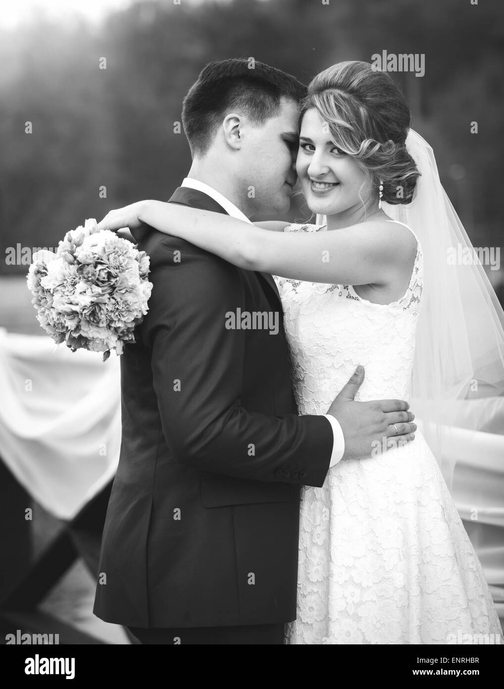 Black and white portrait of hugging and laughing bride and groom at ...