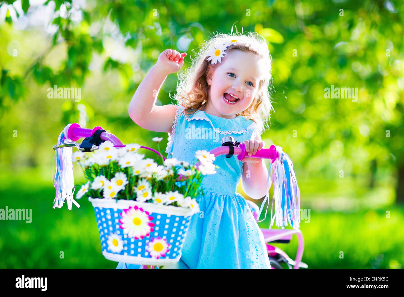Happy child riding a bike. Cute kid biking outdoors. Little girl in a ...