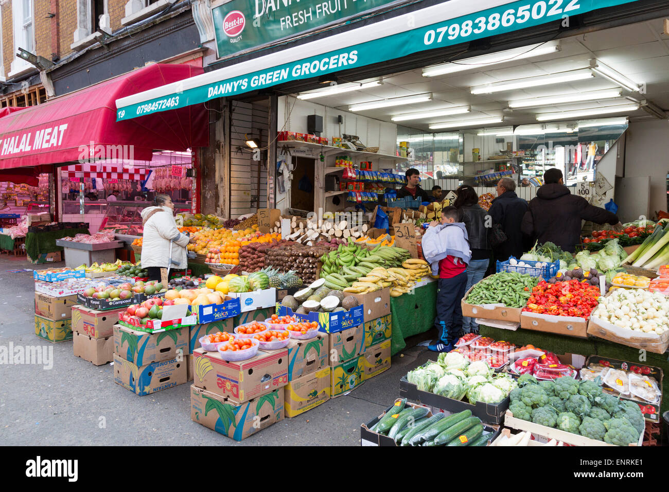 Traditional greengrocers shop with produce on display and customers on ...