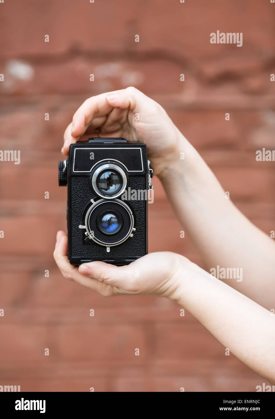 Retro vintage camera in female hands. Old brown vintage grunge wall in ...