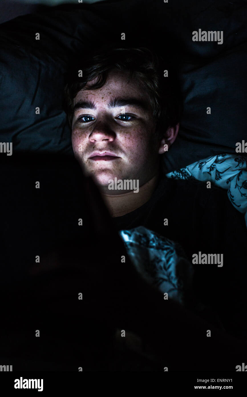 Teenager boy on computer tablet in his room late at night Stock Photo ...
