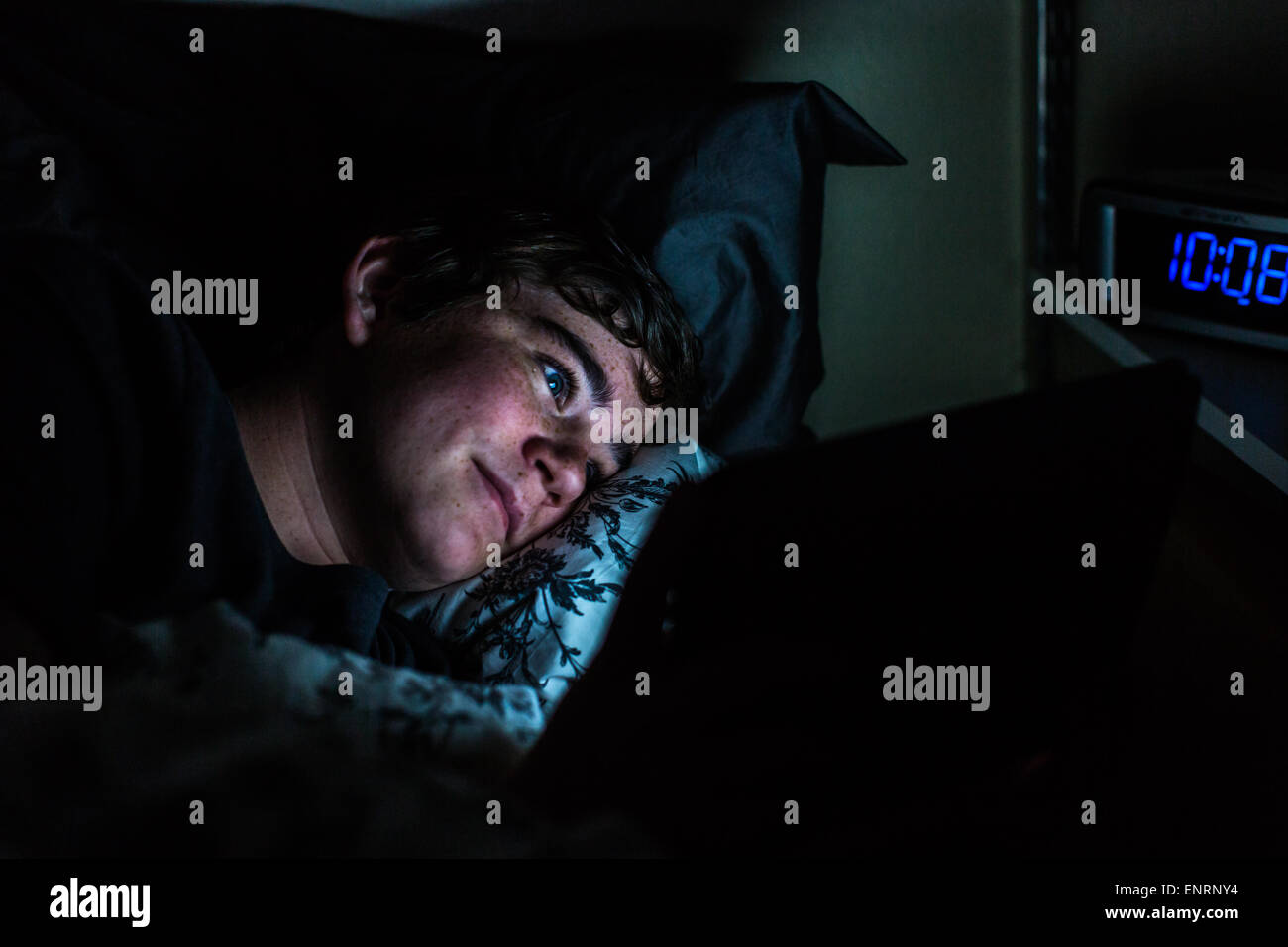 Teenager boy on computer tablet in his room late at night Stock Photo ...