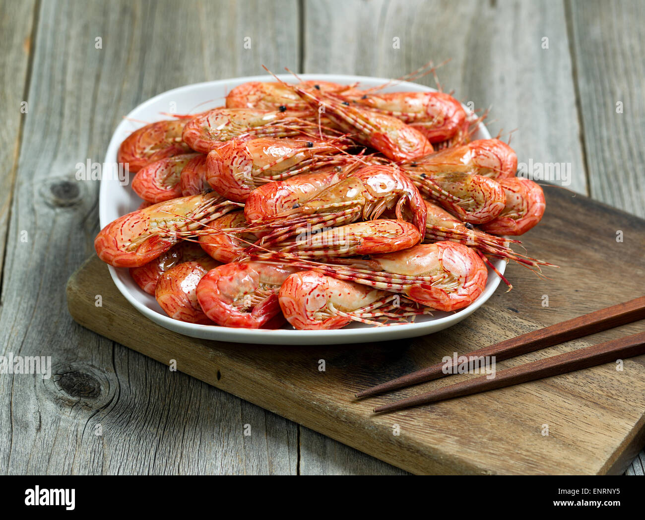 Close up image of cooked shrimp in white plate on top of server with ...