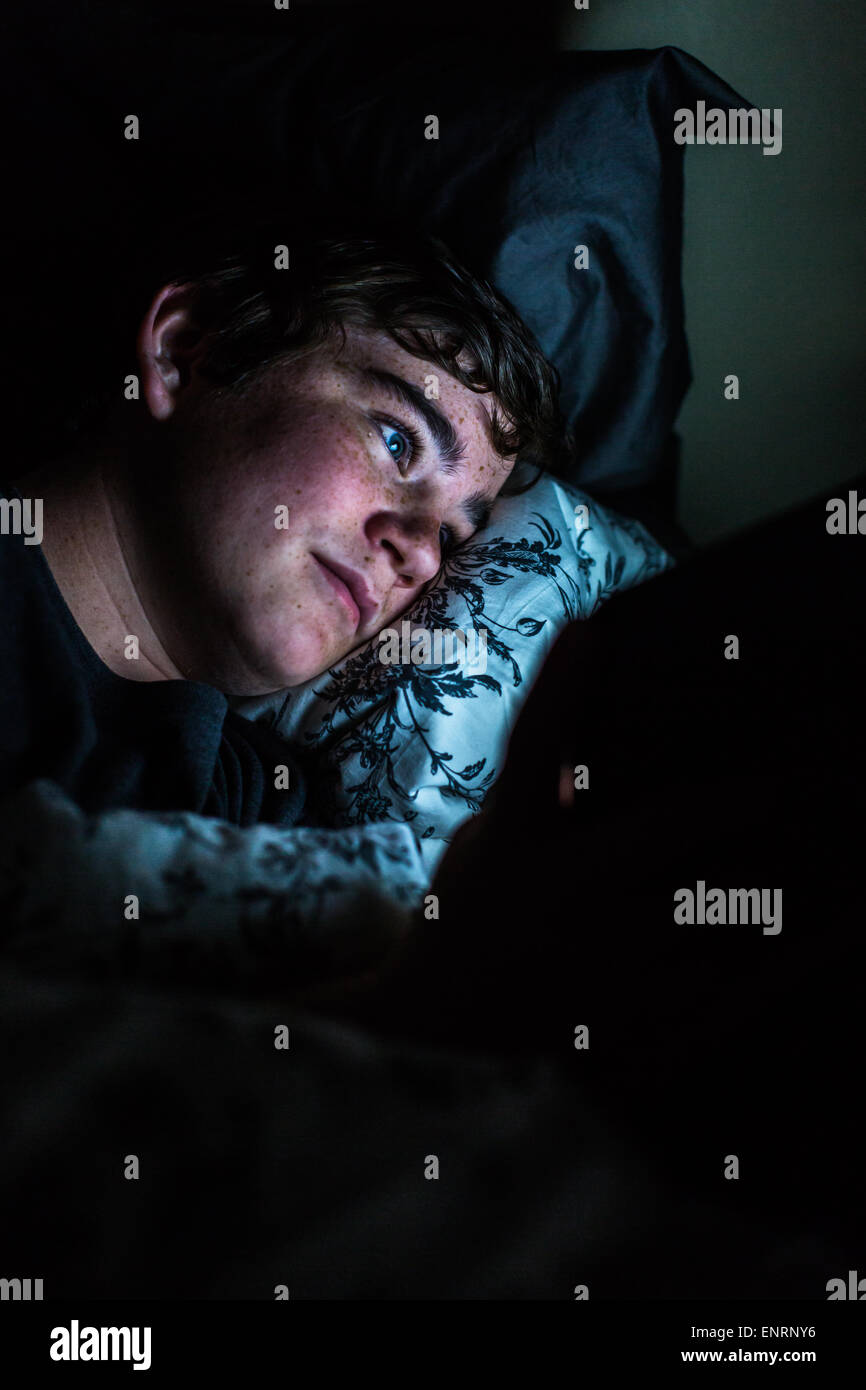 Teenager boy on computer tablet in his room late at night Stock Photo ...