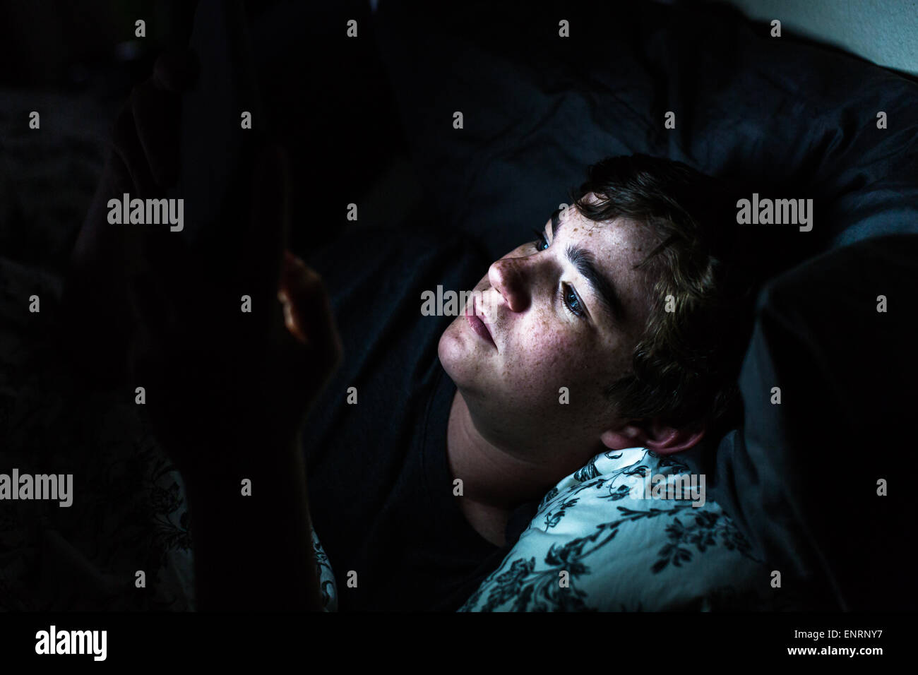 Teenager boy on computer tablet in his room late at night Stock Photo ...
