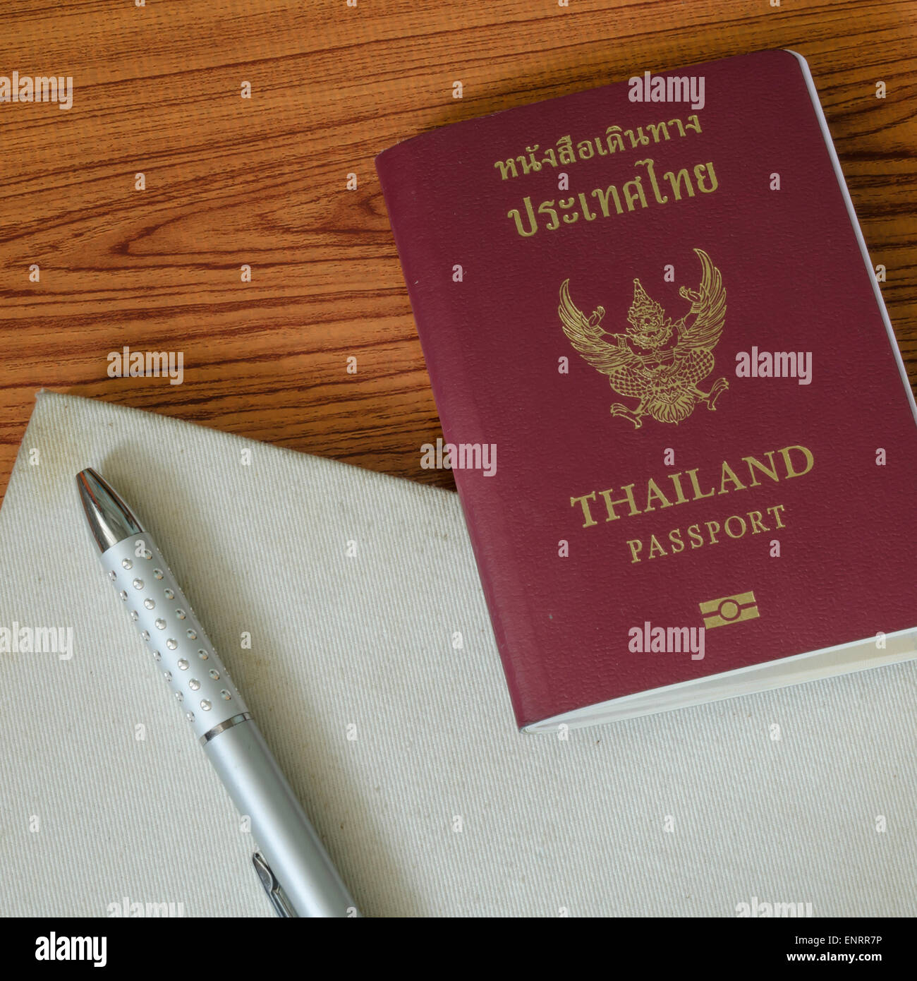 thai passport with notebook on wood table background Stock Photo - Alamy
