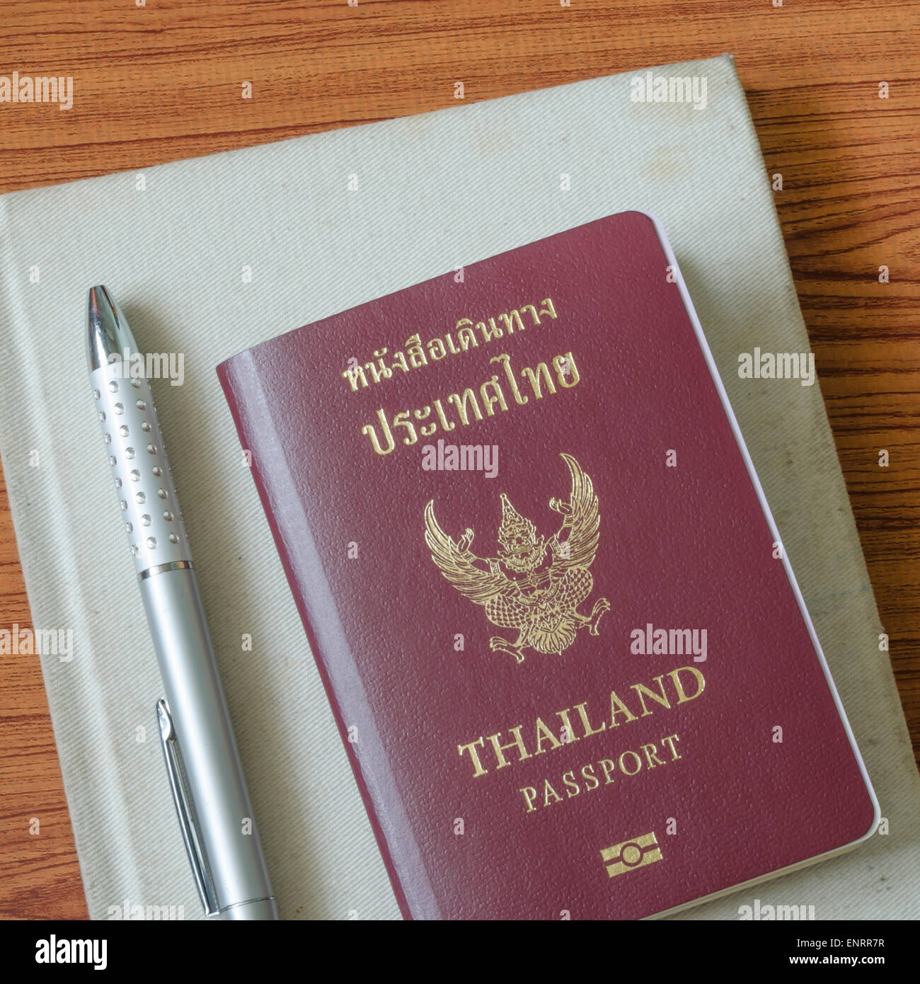 thai passport with notebook on wood table background Stock Photo - Alamy