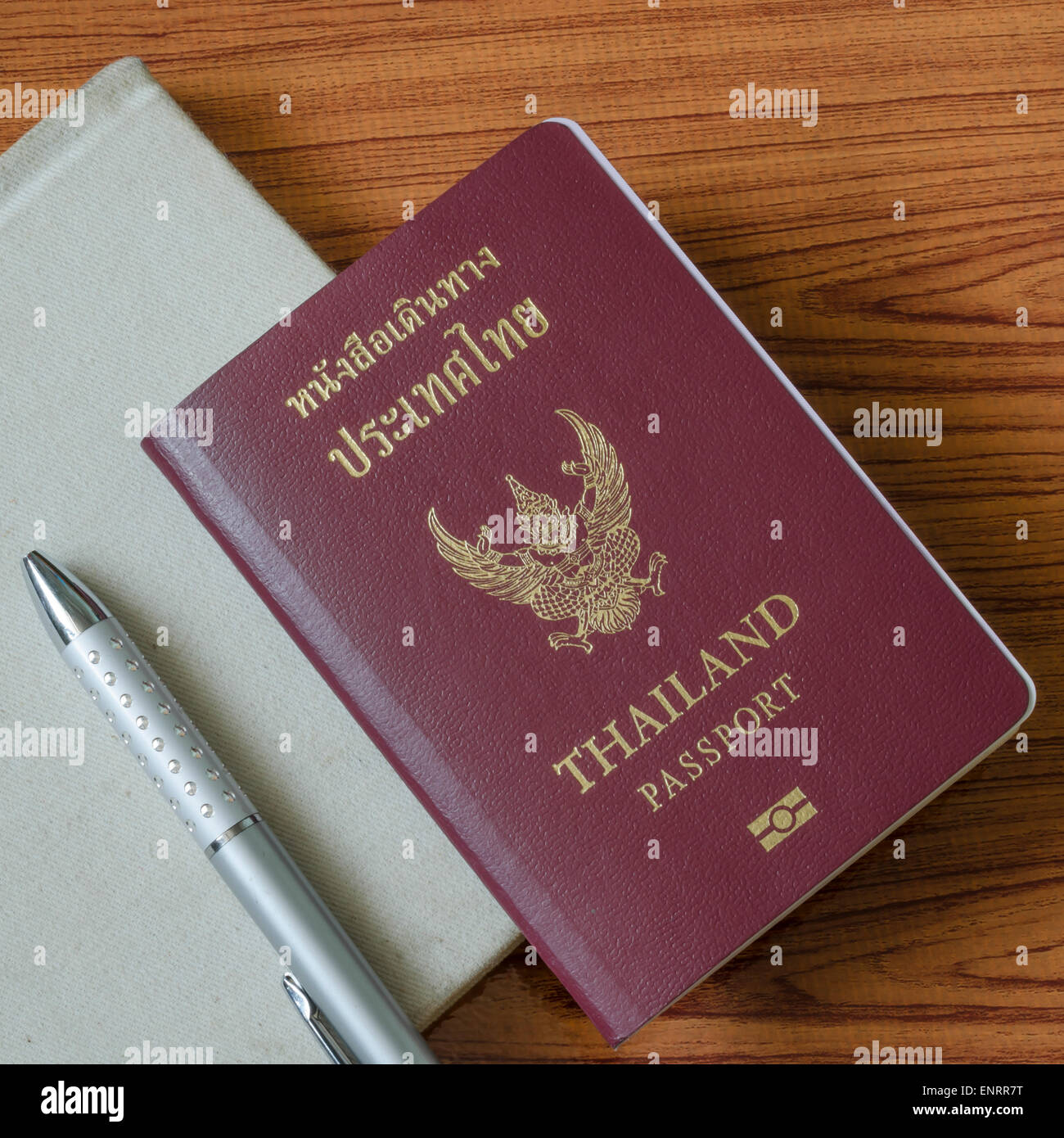 thai passport with notebook on wood table background Stock Photo - Alamy