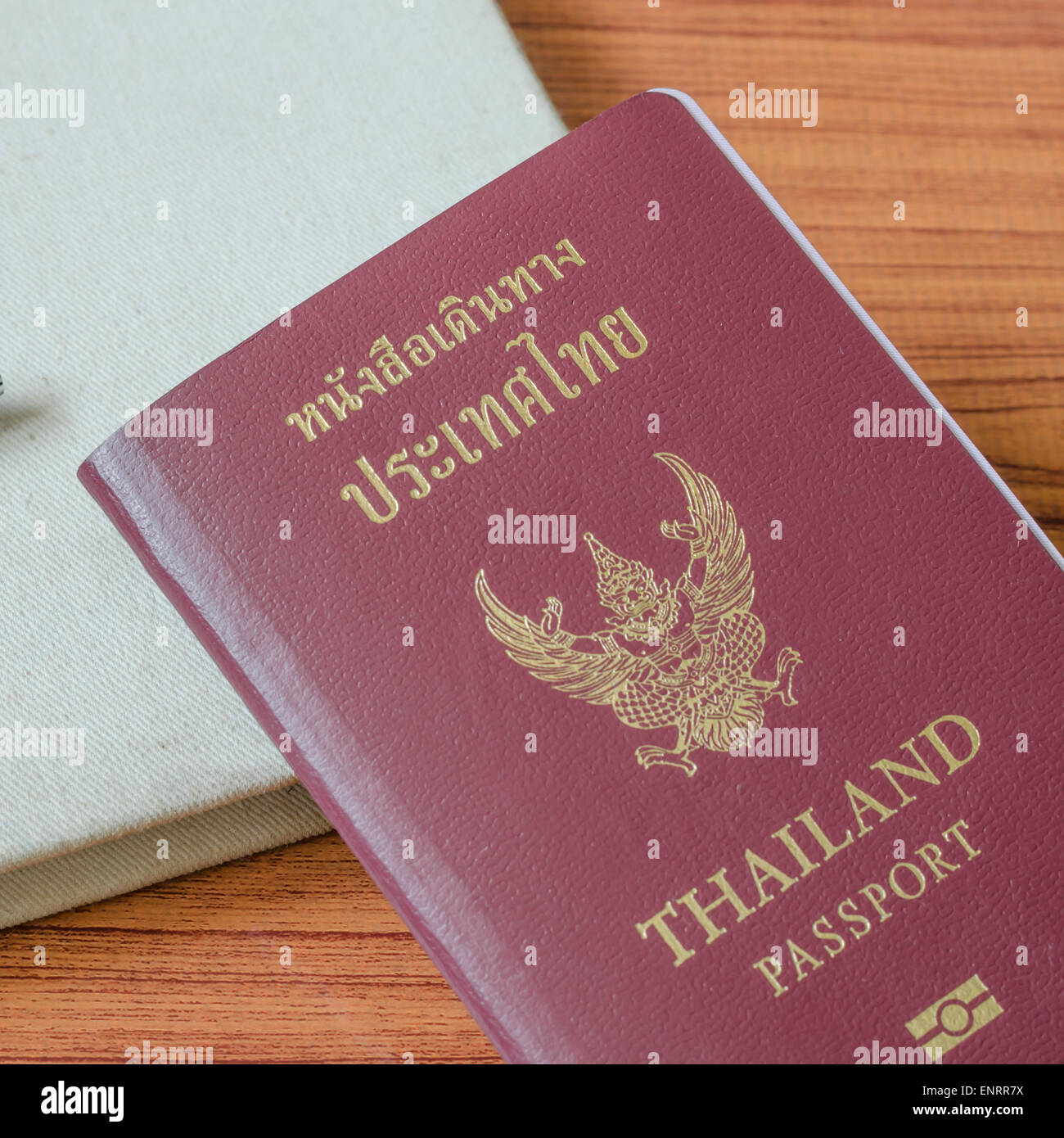 thai passport with notebook on wood table background Stock Photo - Alamy