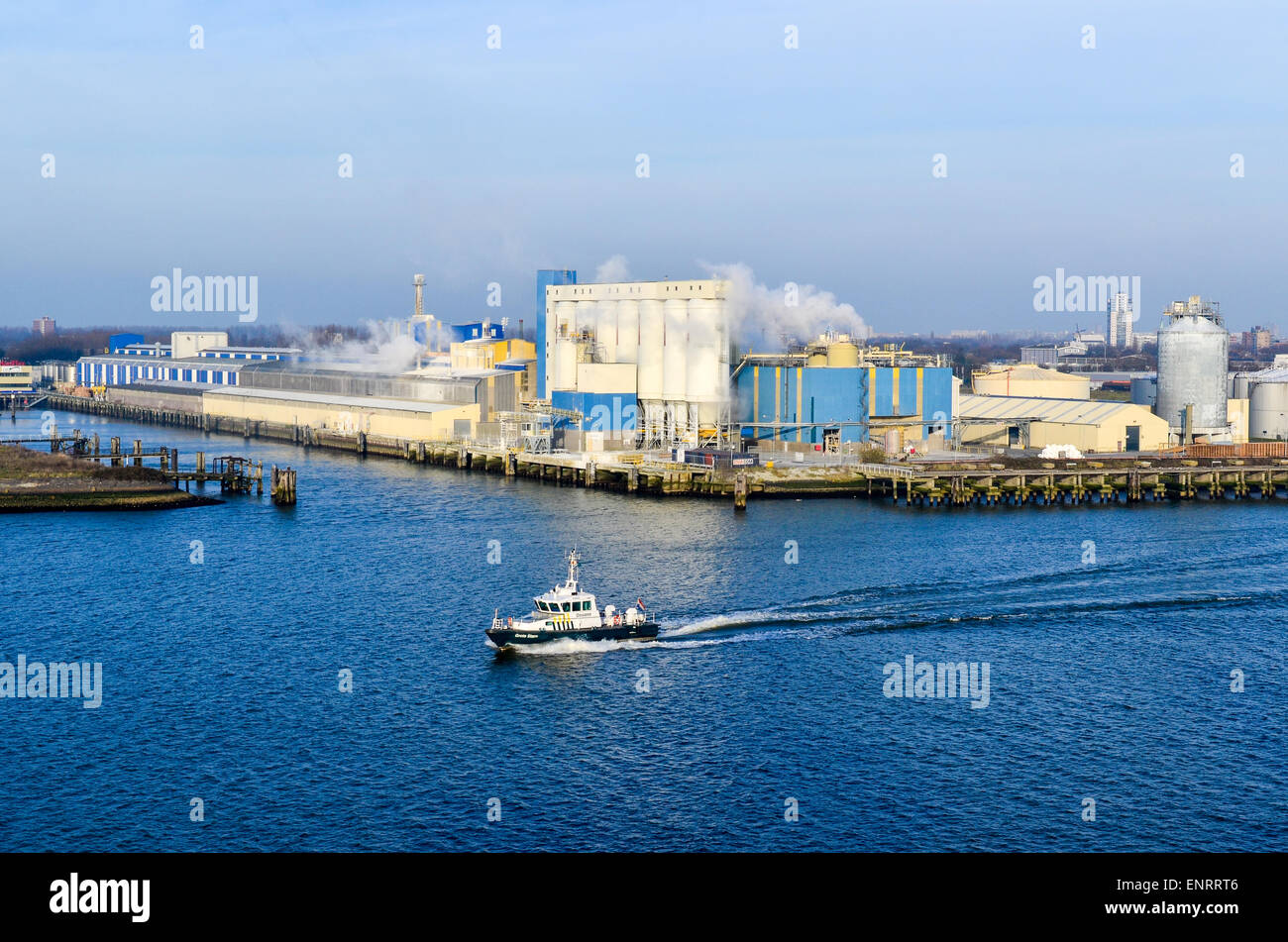 A small boat sailing into the port of Rotterdam, Netherlands, passing ...