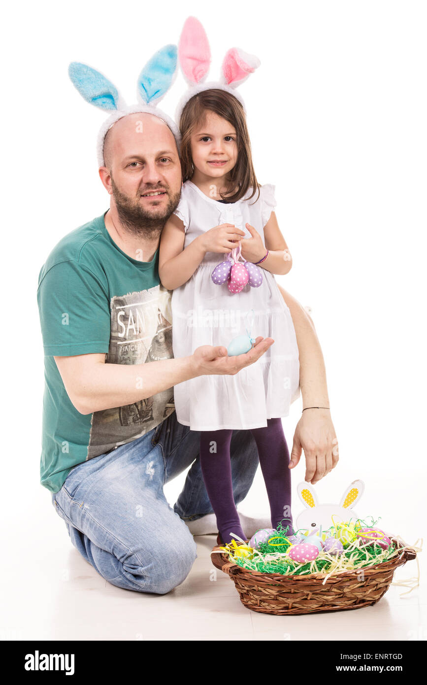 Father and daughter with bunny ears showing Easter eggs from basket ...