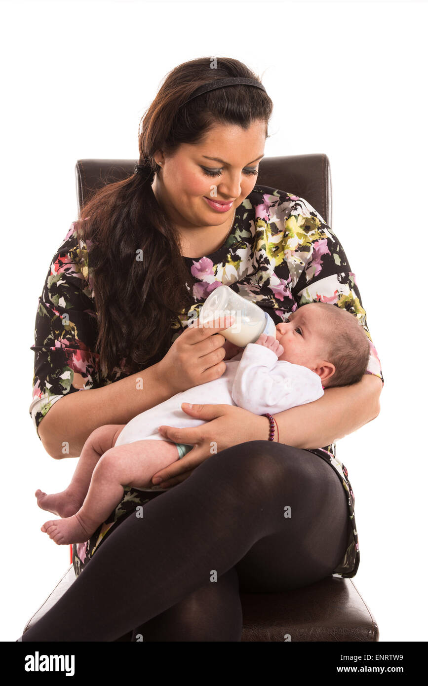 Mother feed her newborn baby girl with milk isolated on white ...