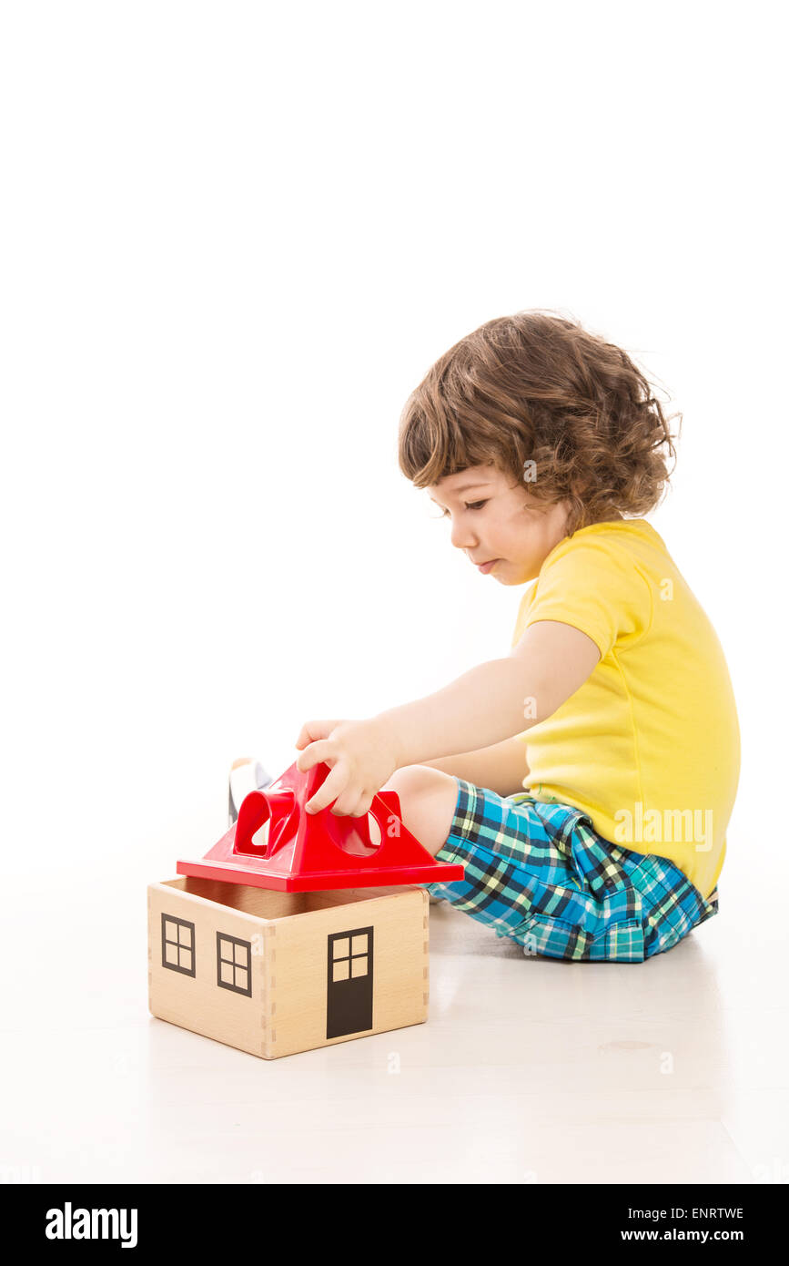 Toddler boy playing with wooden house against white background Stock ...