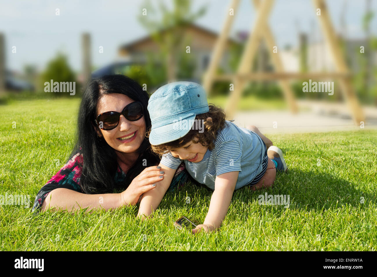 Happy mother and toddler son having fun outdoor on grass in countryside ...