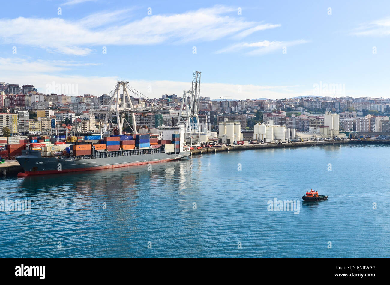 Small tugboat going towards a large container ship at the container ...
