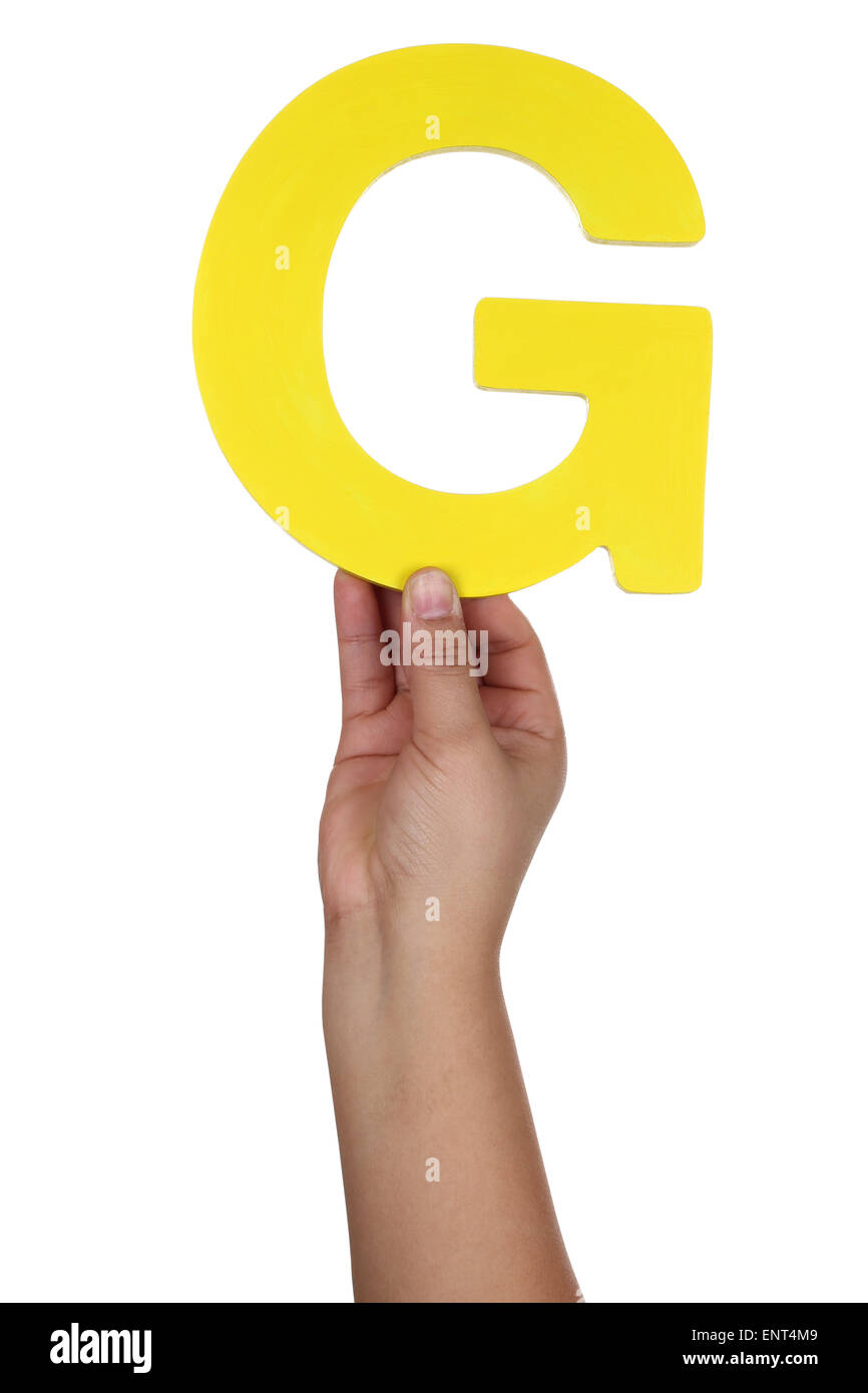 Hand holding letter G from alphabet isolated on a white background ...