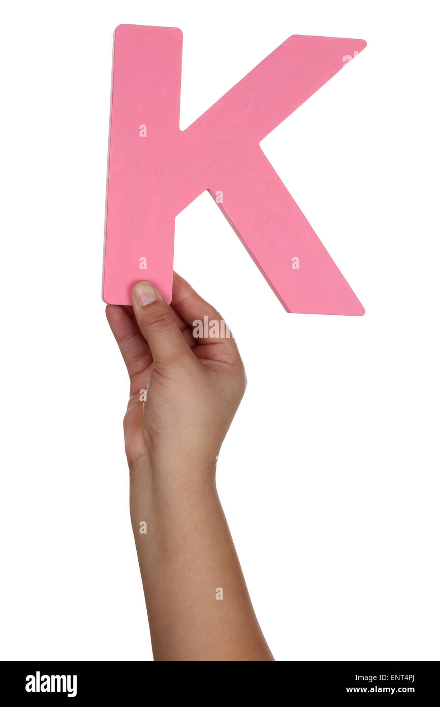 Hand holding letter K from alphabet isolated on a white background ...