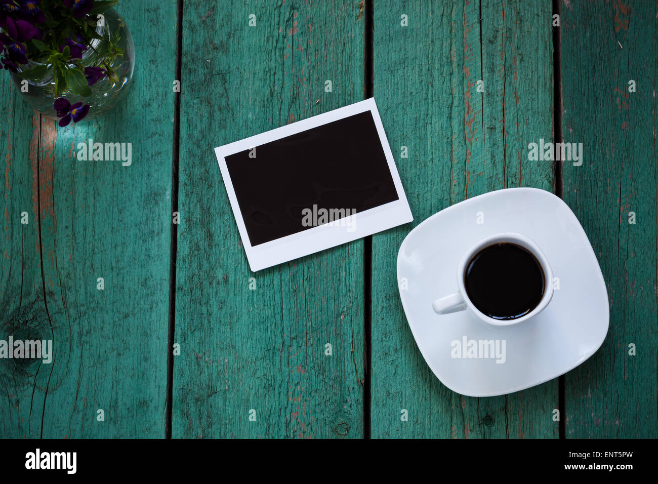 Empty photo card and a cup of coffee on old green wooden board, memory ...