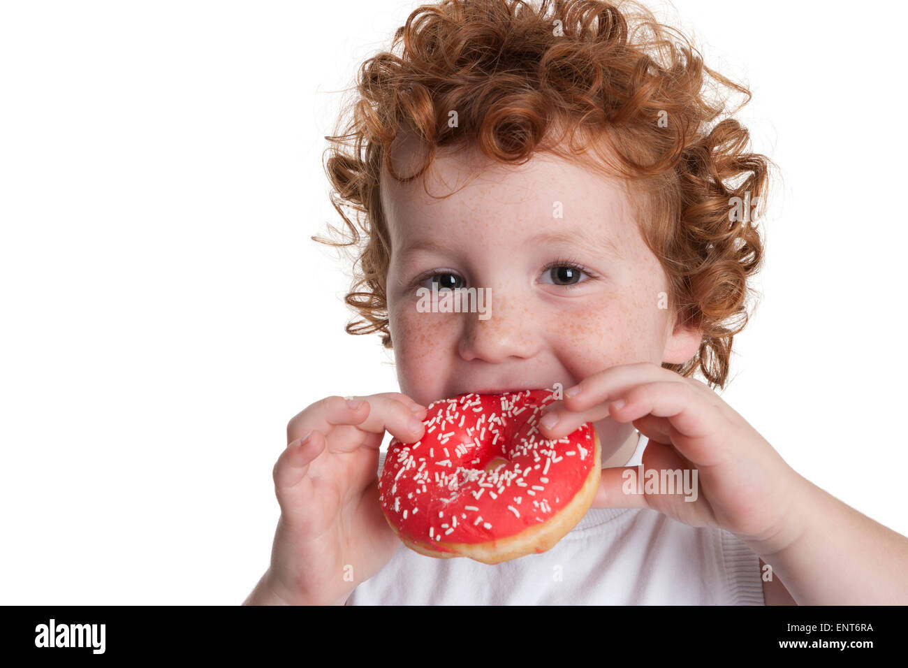 Curly red haired boy eating a donut on white background with space for ...
