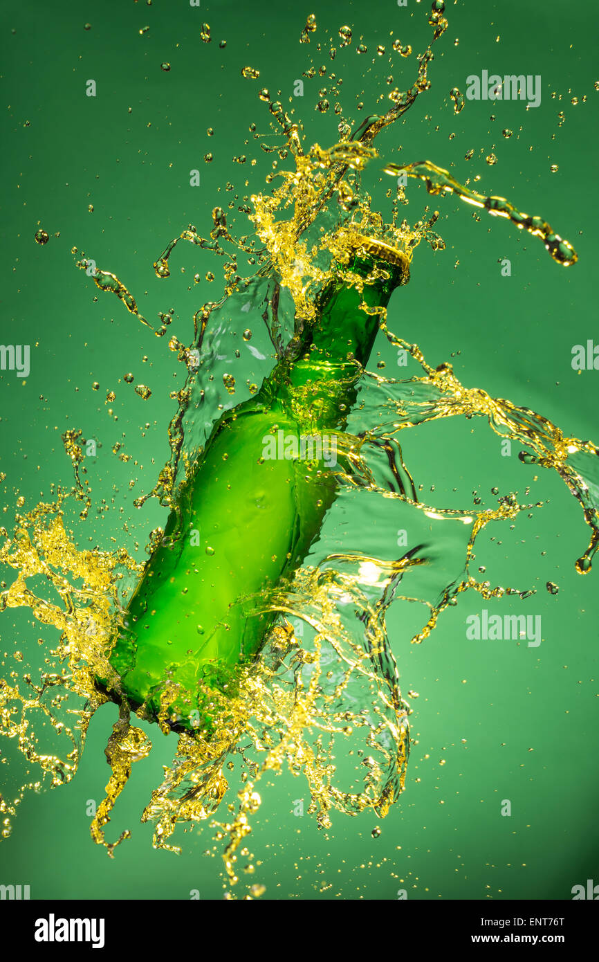 Green beer bottle with splashing liquid, freeze motion Stock Photo - Alamy