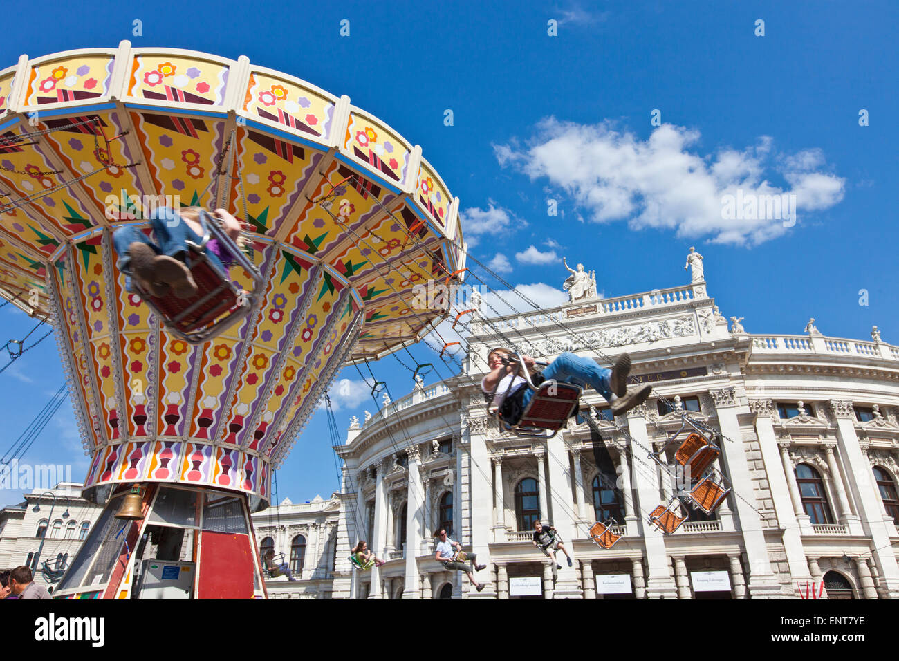 Some people enjoy a ride on a old-fashioned style Carousel in front of ...