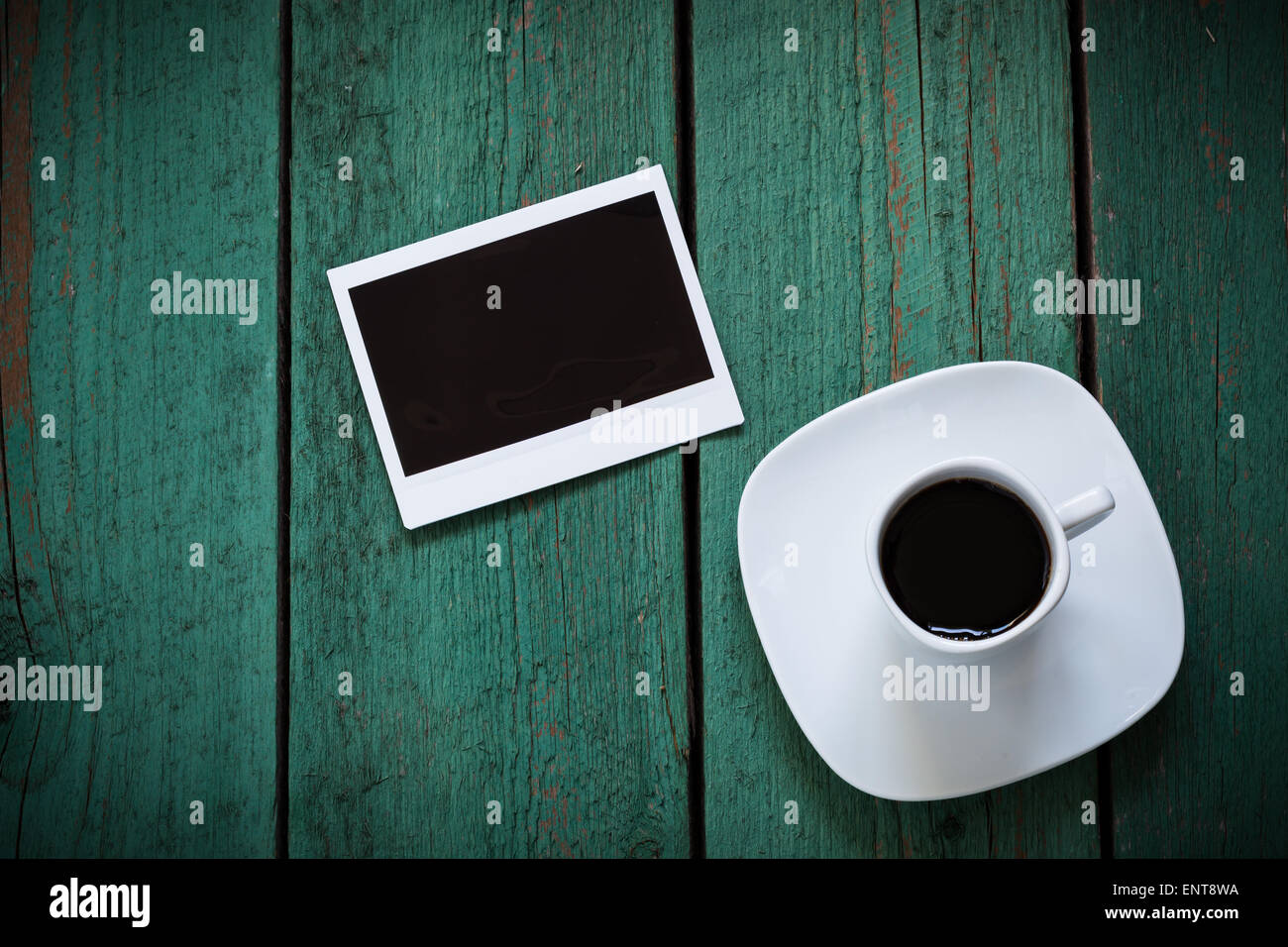 Empty photo card and a cup of coffee on old green wooden board, memory ...