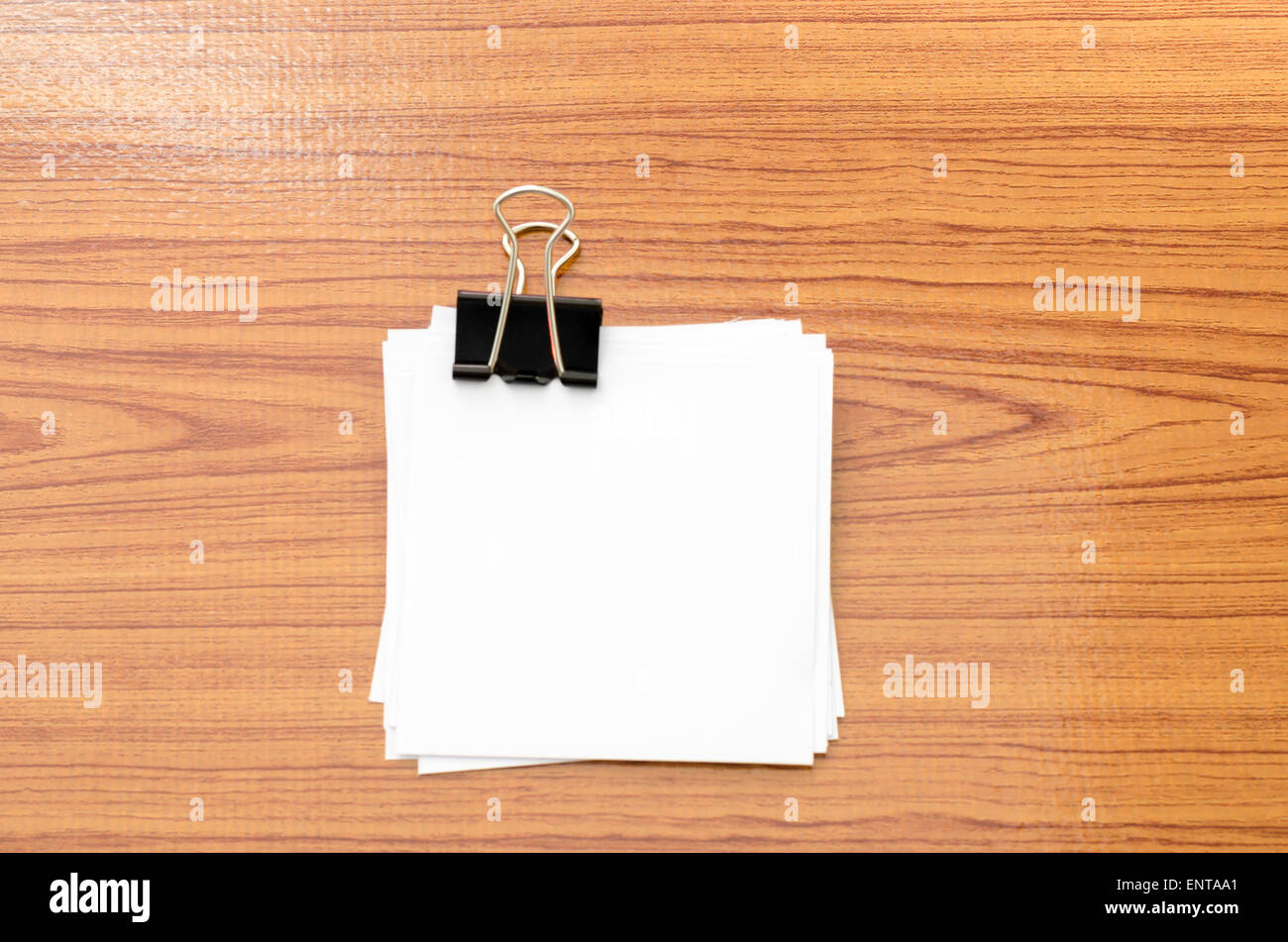 stack of paper with clip on wood background Stock Photo - Alamy