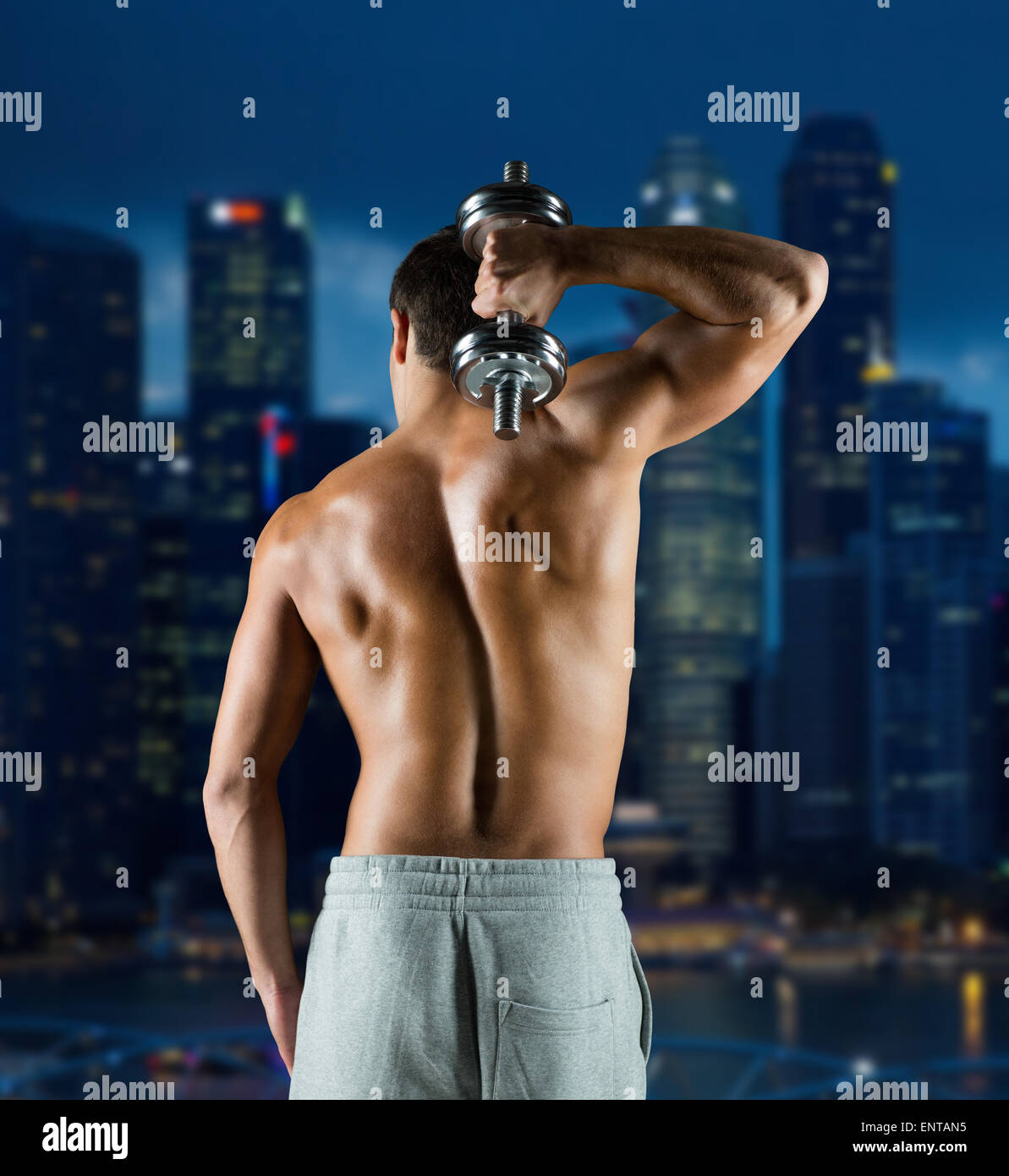young man with dumbbell flexing biceps Stock Photo - Alamy