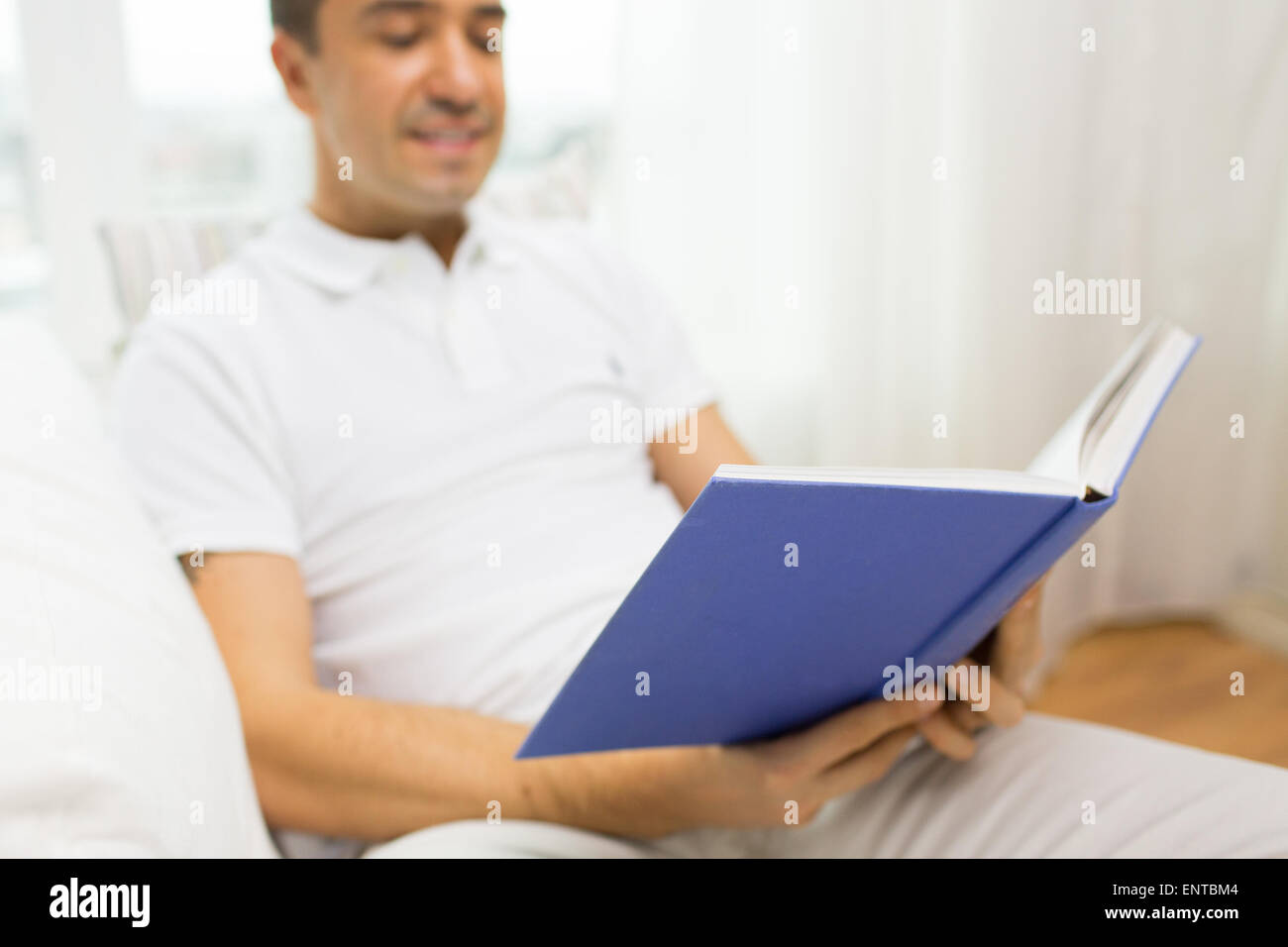 close up of happy man reading book at home Stock Photo - Alamy