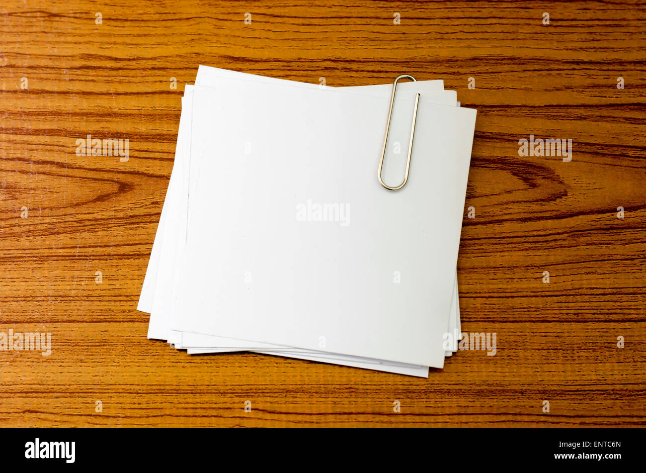 stack of paper with clip on wood background Stock Photo - Alamy
