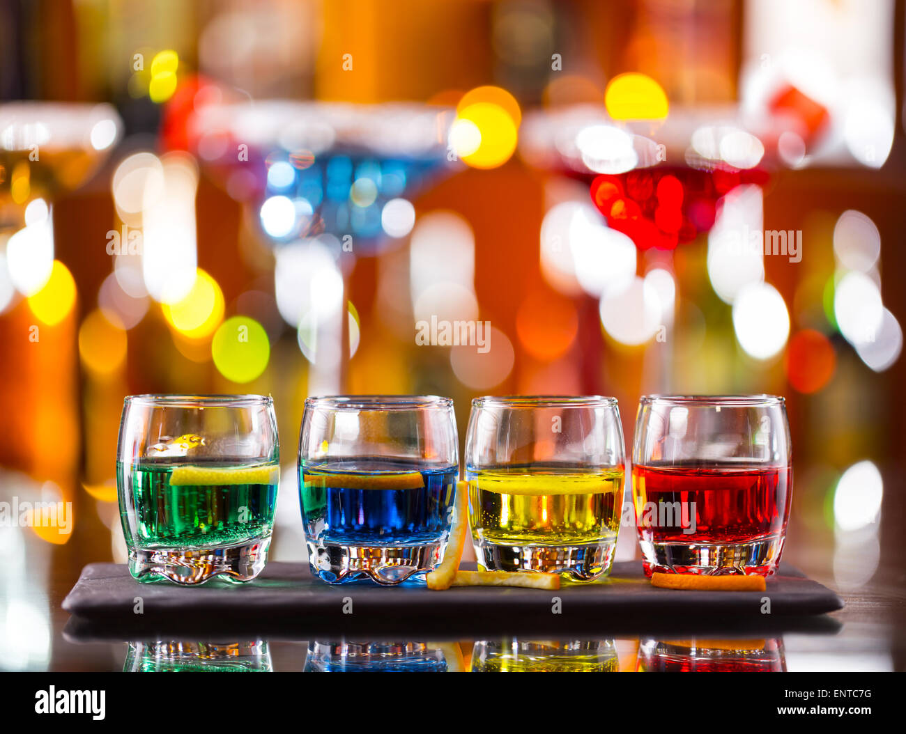 Variation of hard alcoholic shots served on bar counter. Blur bottles ...