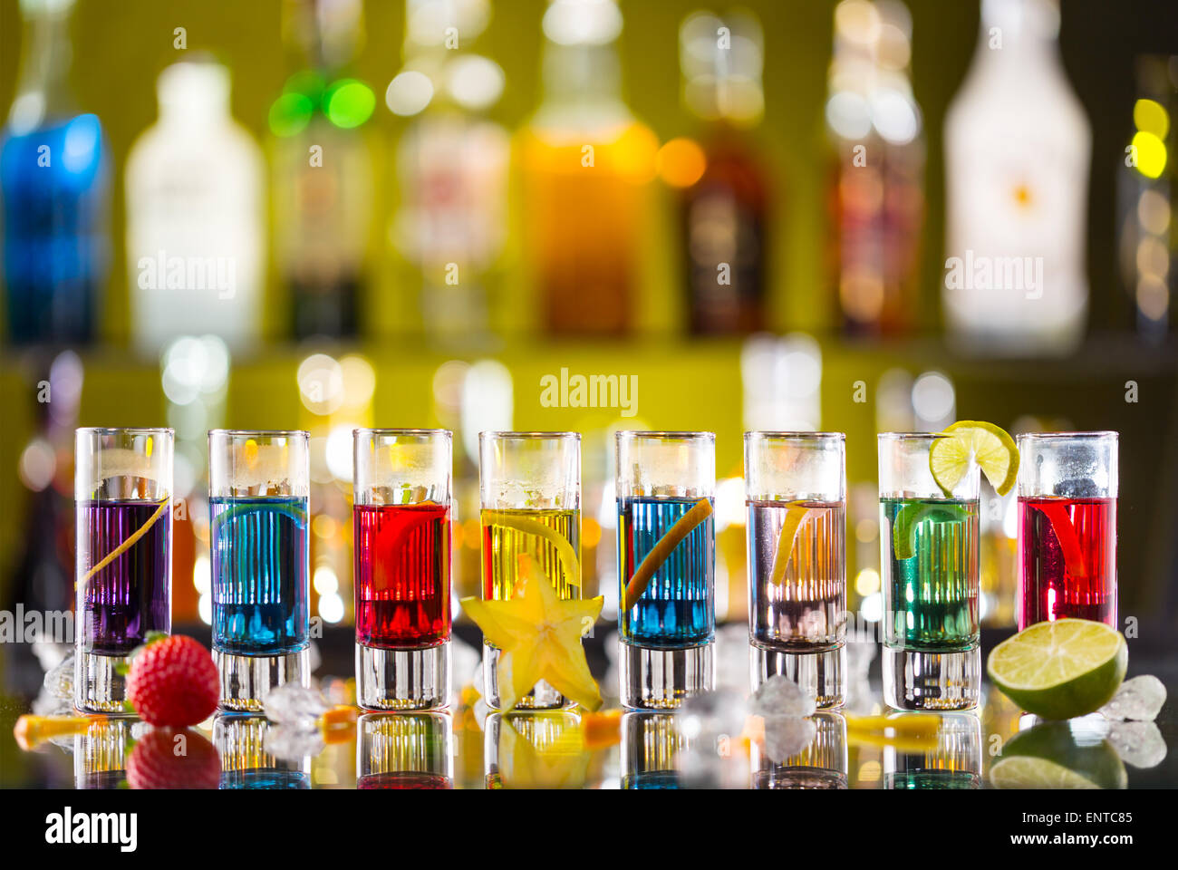 Variation of hard alcoholic shots served on bar counter. Blur bottles ...