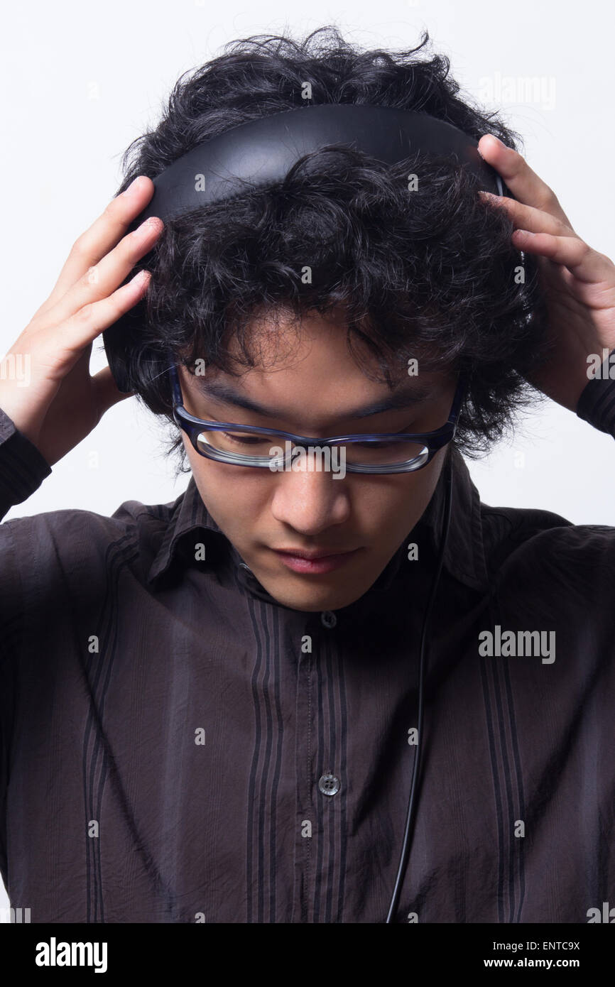 Asian young man wearing head phones with eyes closed Stock Photo - Alamy