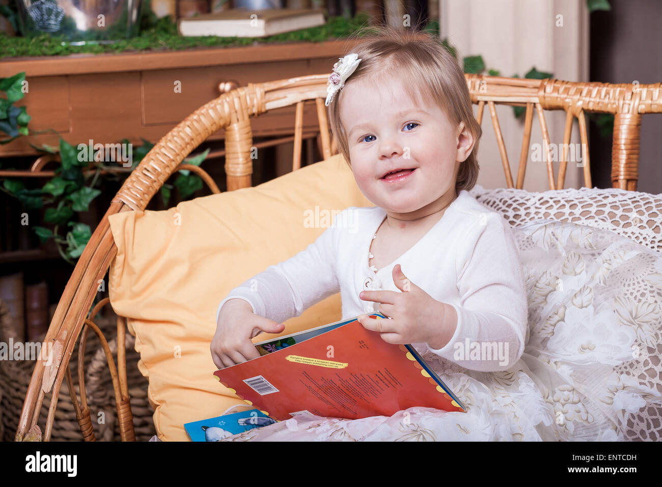 Sweet happy little girl reading book Stock Photo - Alamy