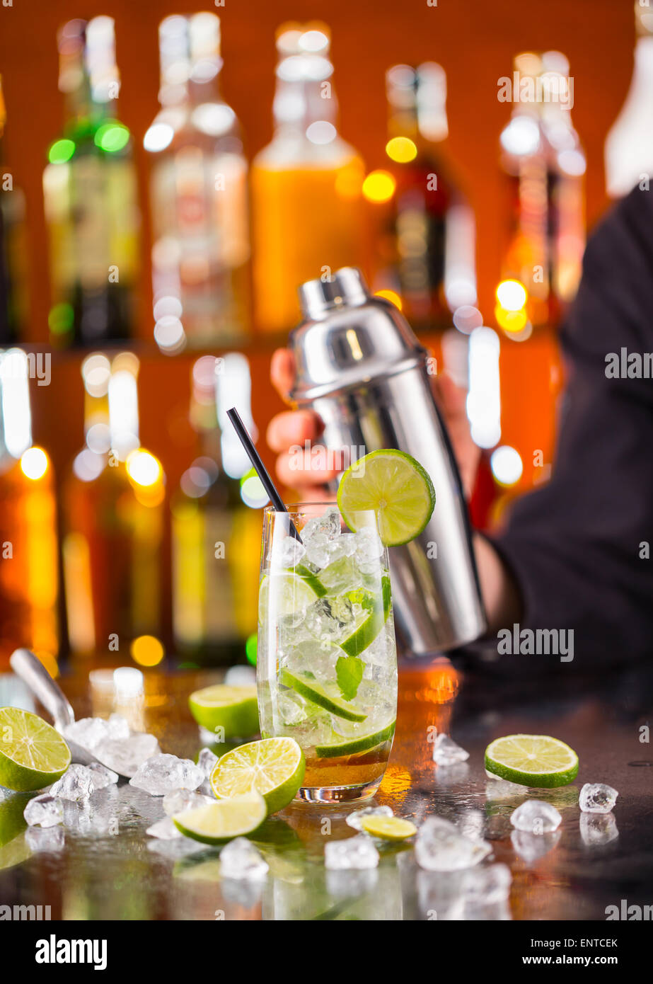 Mojito cocktail drink on bar counter with barman holding shaker on ...