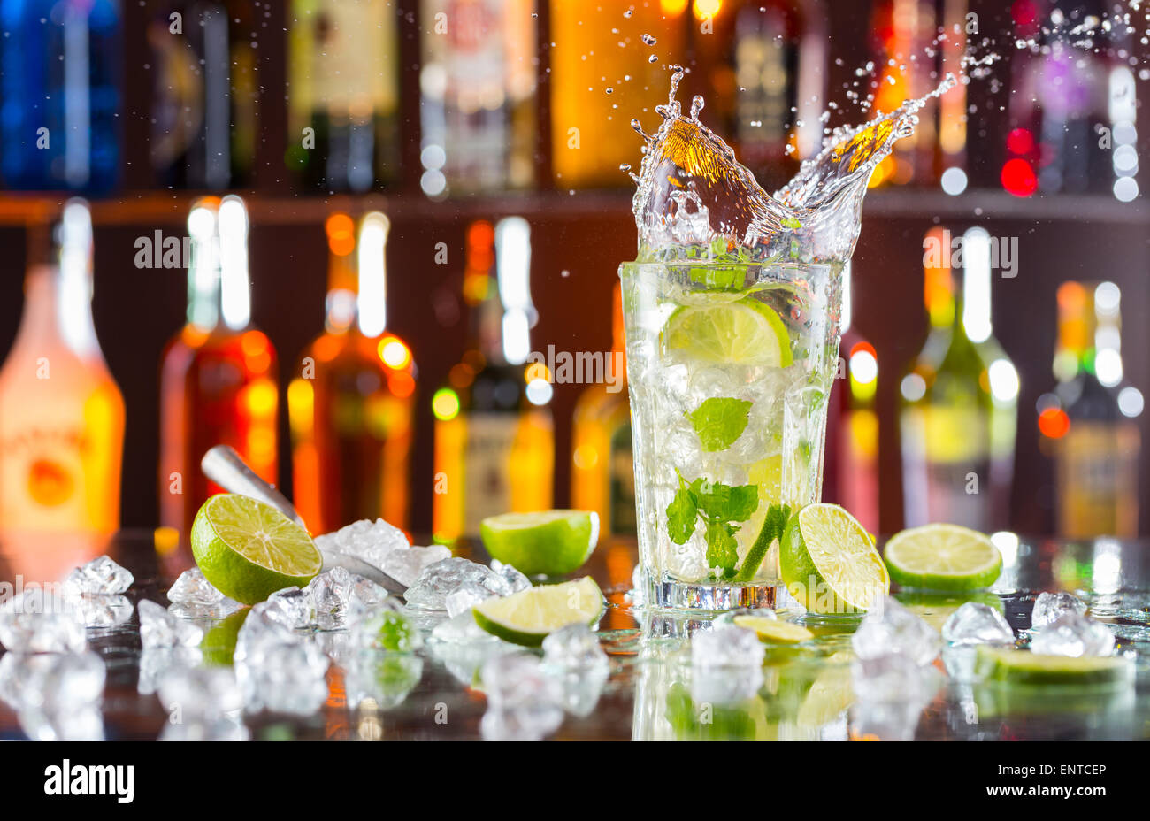 Mojito cocktail drink with splash, served on bar counter with blur ...