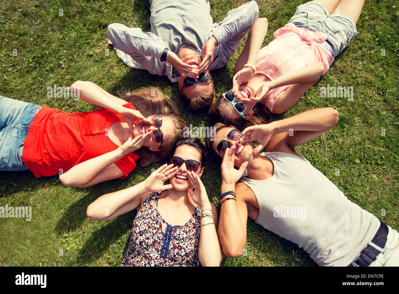 group of smiling friends lying on grass outdoors Stock Photo - Alamy