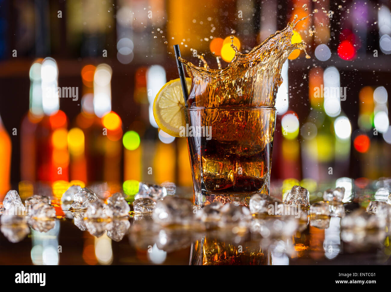 Glass of cola drink on bar counter with ice cubes Stock Photo - Alamy