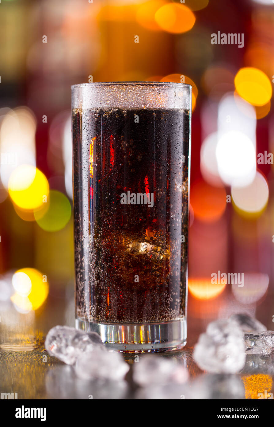 Glass of cola drink on bar counter with ice cubes Stock Photo - Alamy
