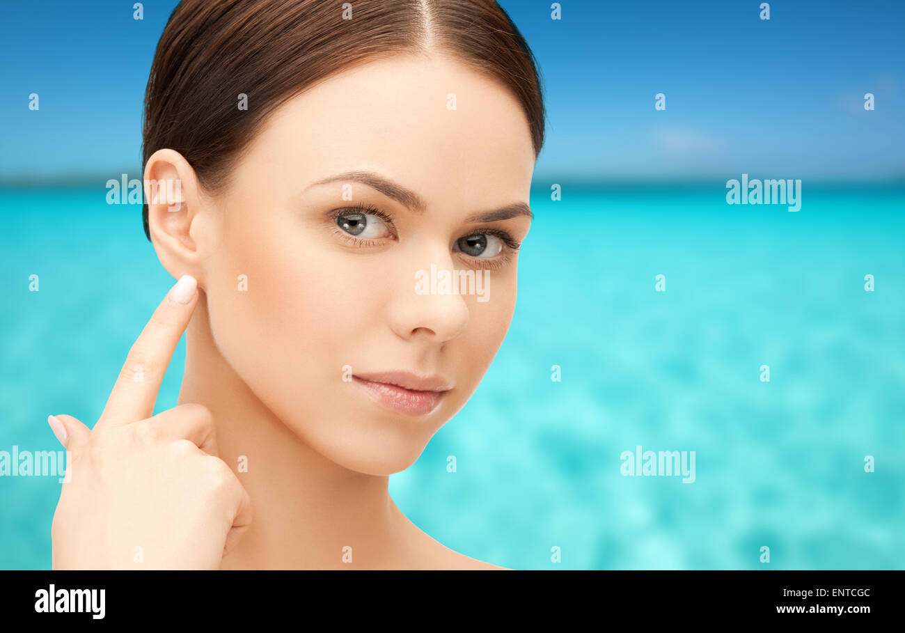 face of beautiful woman touching her ear Stock Photo - Alamy