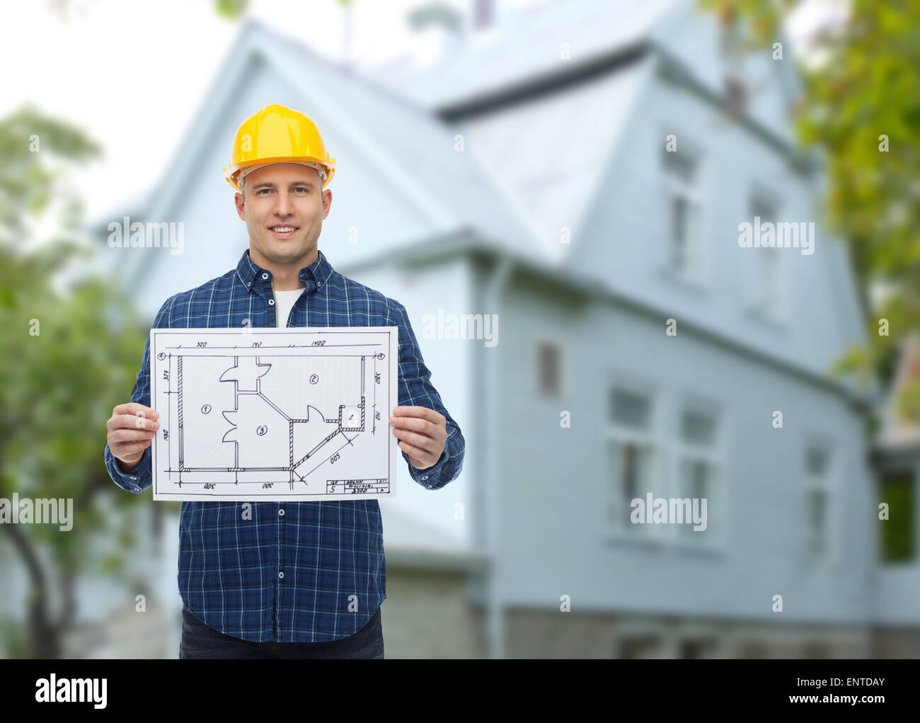 smiling builder with blueprint over house Stock Photo - Alamy