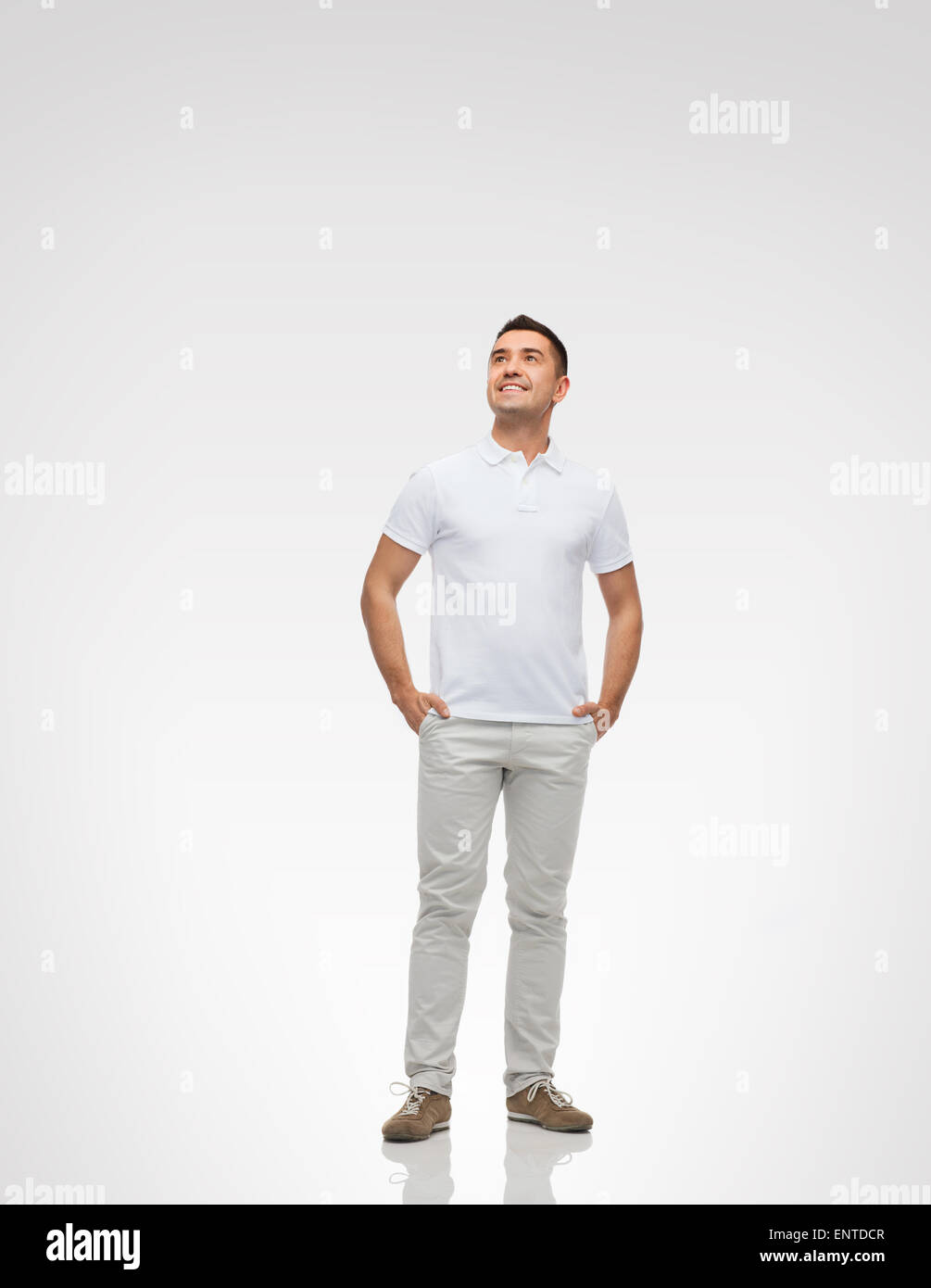 smiling man with hands in pockets looking up Stock Photo - Alamy