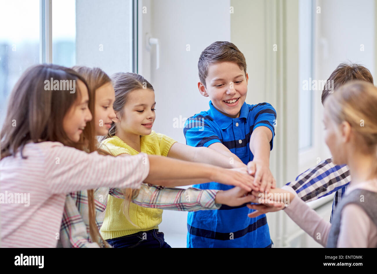 group of smiling school kids putting hands on top Stock Photo - Alamy