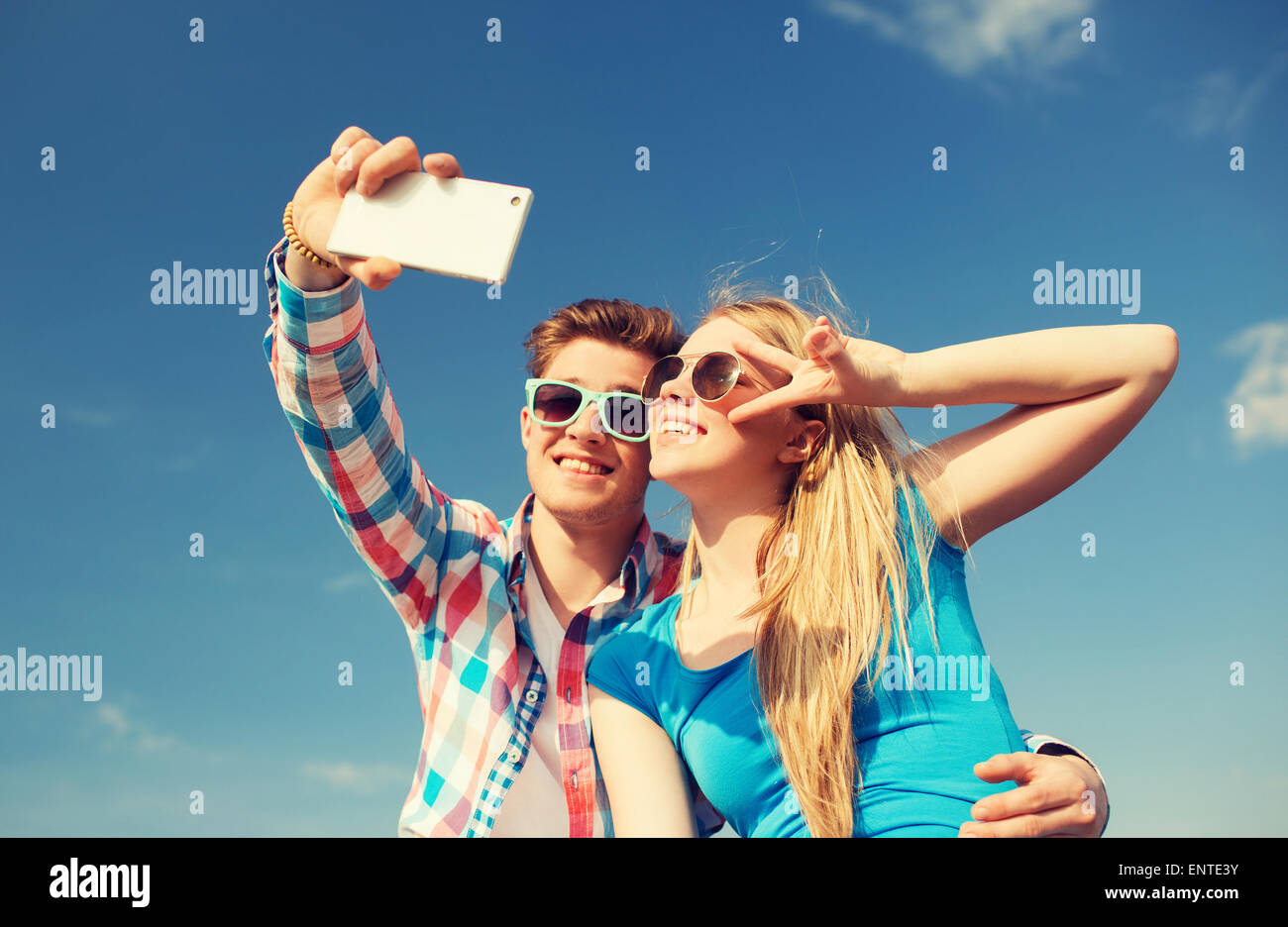 smiling couple with smartphone making selfie Stock Photo - Alamy