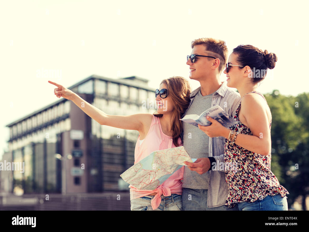 smiling friends with map and city guide outdoors Stock Photo - Alamy